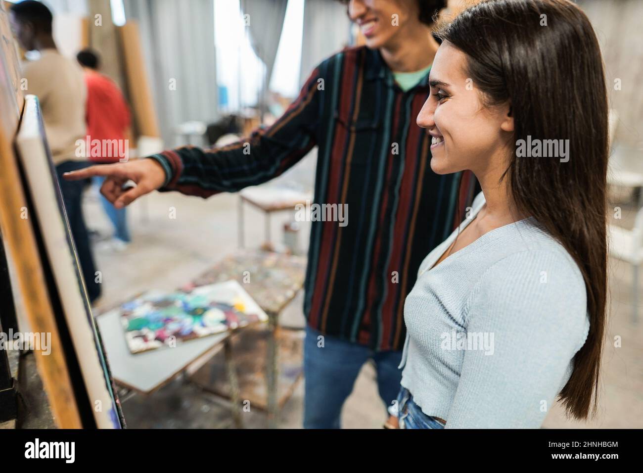 Young students painting inside art room class at university - Focus on ...