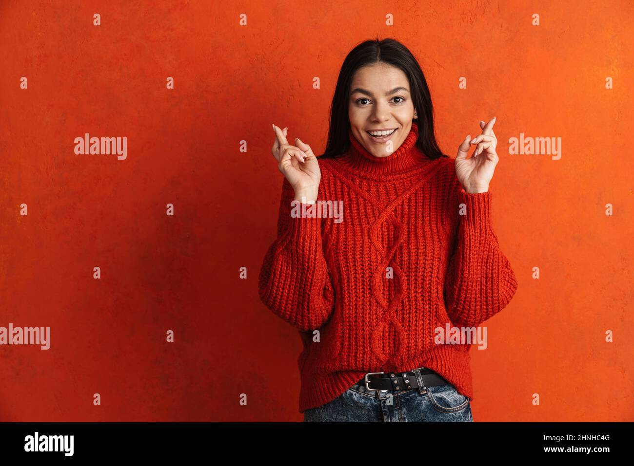 Young hispanic woman holding fingers crossed for good luck isolated ...
