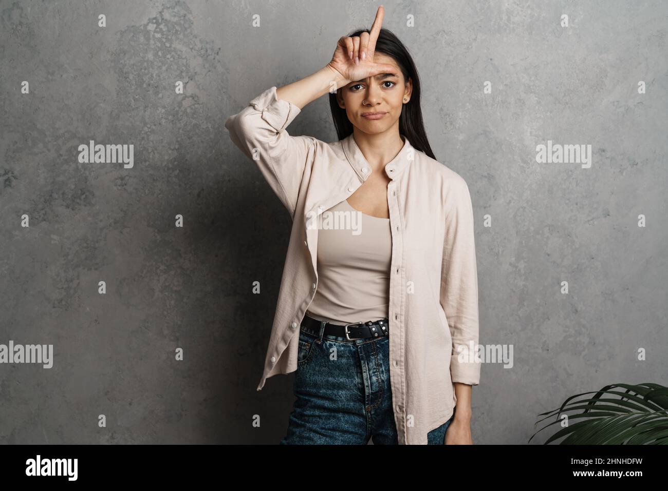 Brunette hispanic woman frowning and pointing finger upward isolated ...