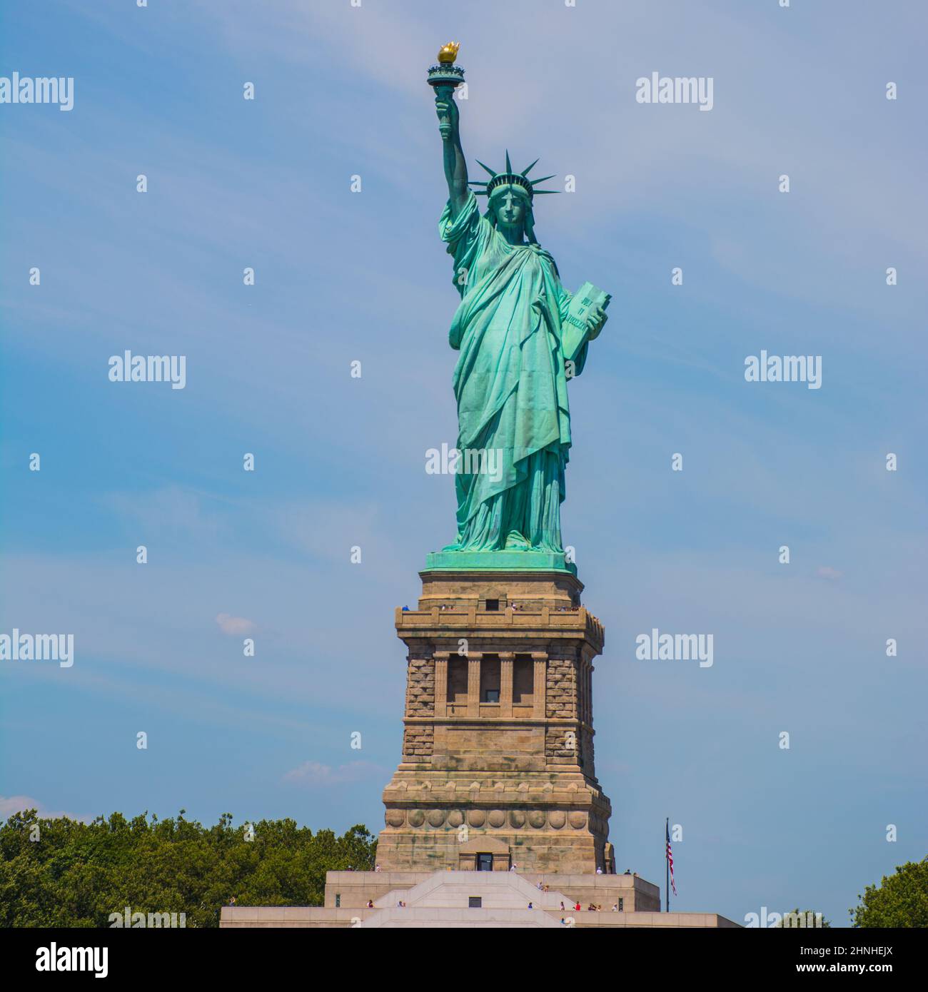 portrait of the statue of liberty with a slightly hazy blue sky and ...