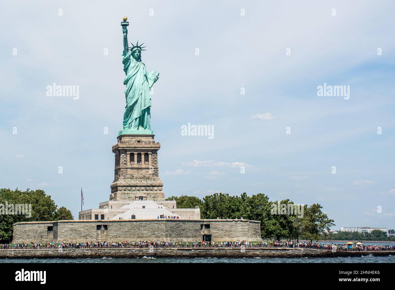 portrait of the statue of liberty with a slightly hazy blue sky and ...