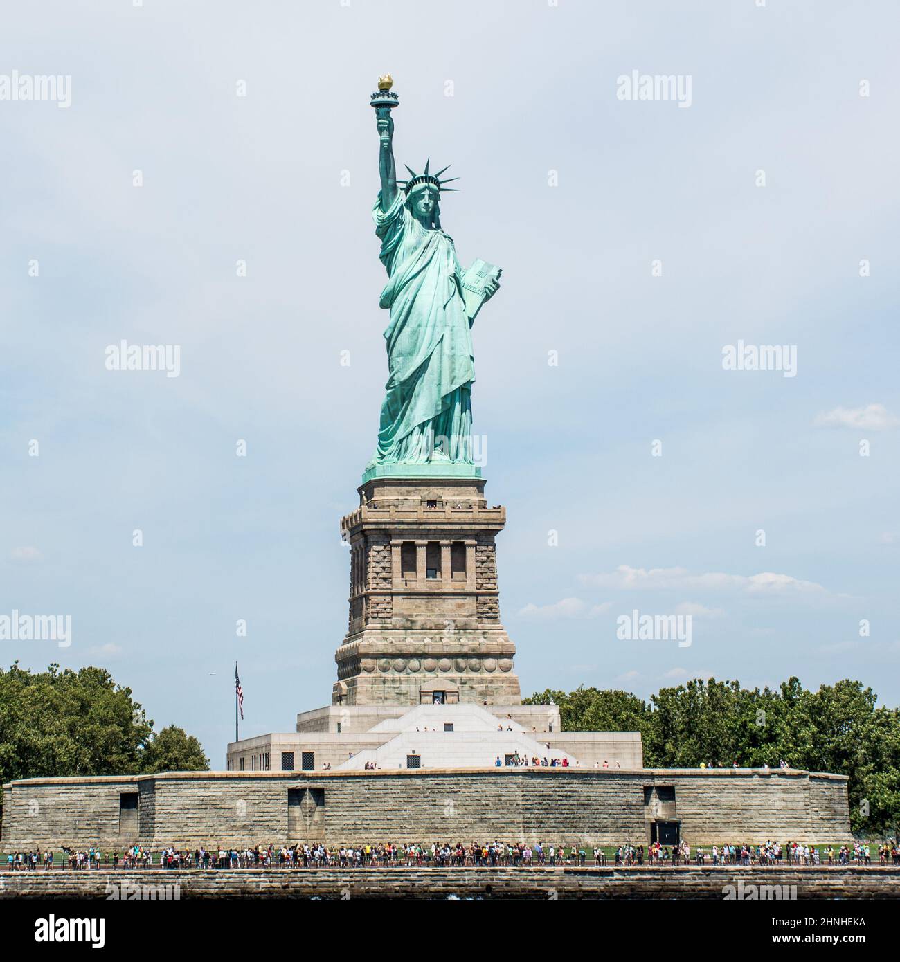 portrait of the statue of liberty with a slightly hazy blue sky and ...