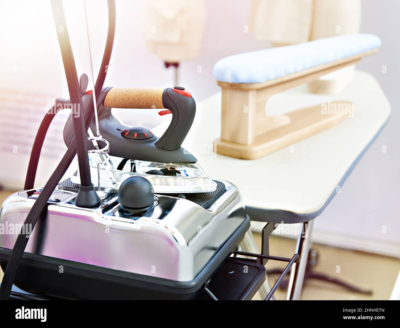 Modern clothes iron and ironing board in sewing workshop Stock Photo ...