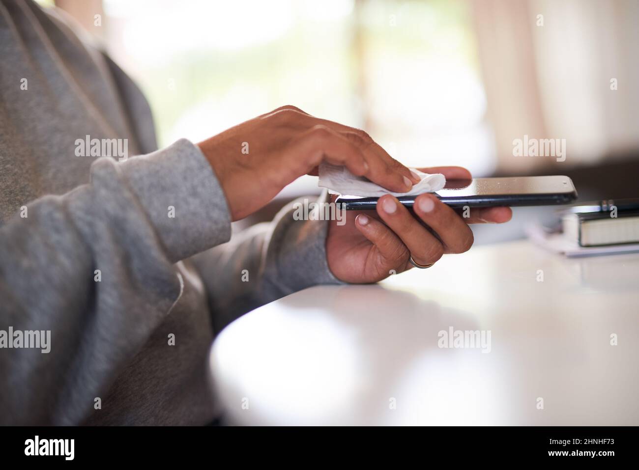 A man wipes his mobile phone screen to clean it from germs Stock Photo ...