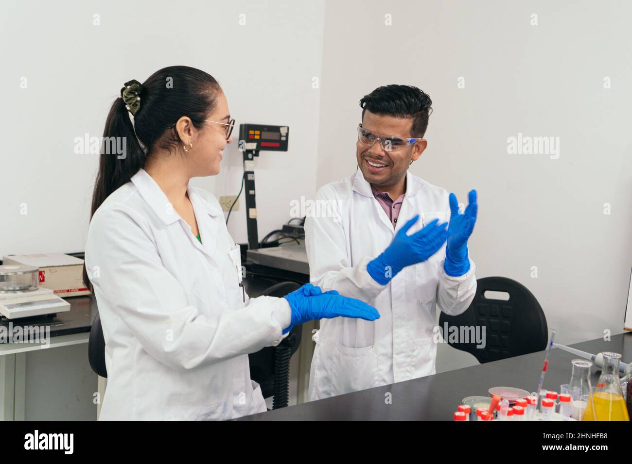 Scientists preparing for laboratory work. Lab technicians putting on ...