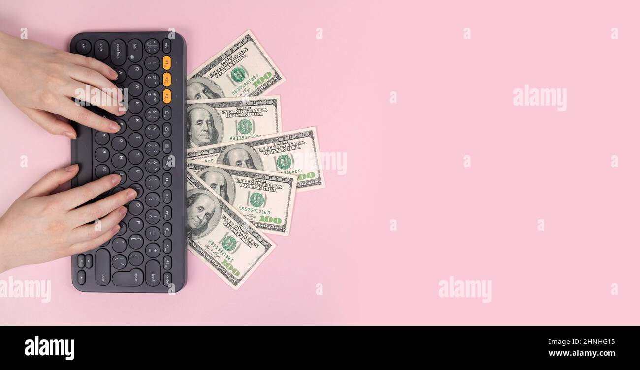 Keyboard and dollar bills. Female hands typing on wireless keyboard ...