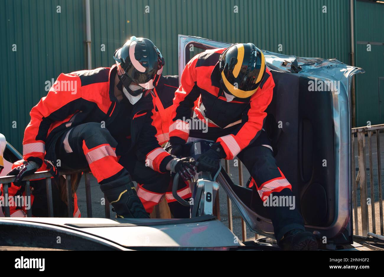 Two firefighters rescuing a victim from an accidented car Stock Photo ...