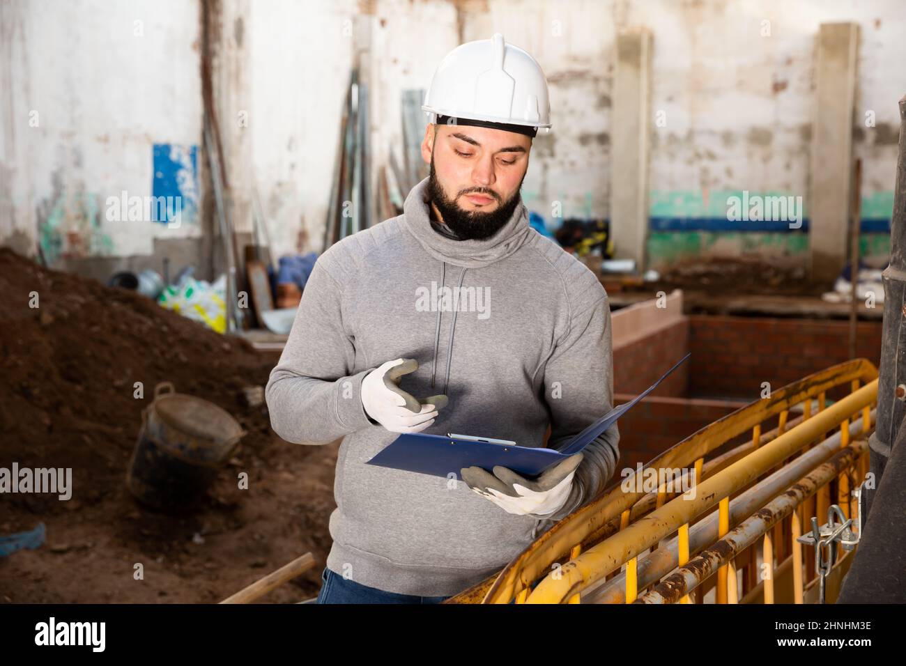 Foreman making task list during building works Stock Photo - Alamy