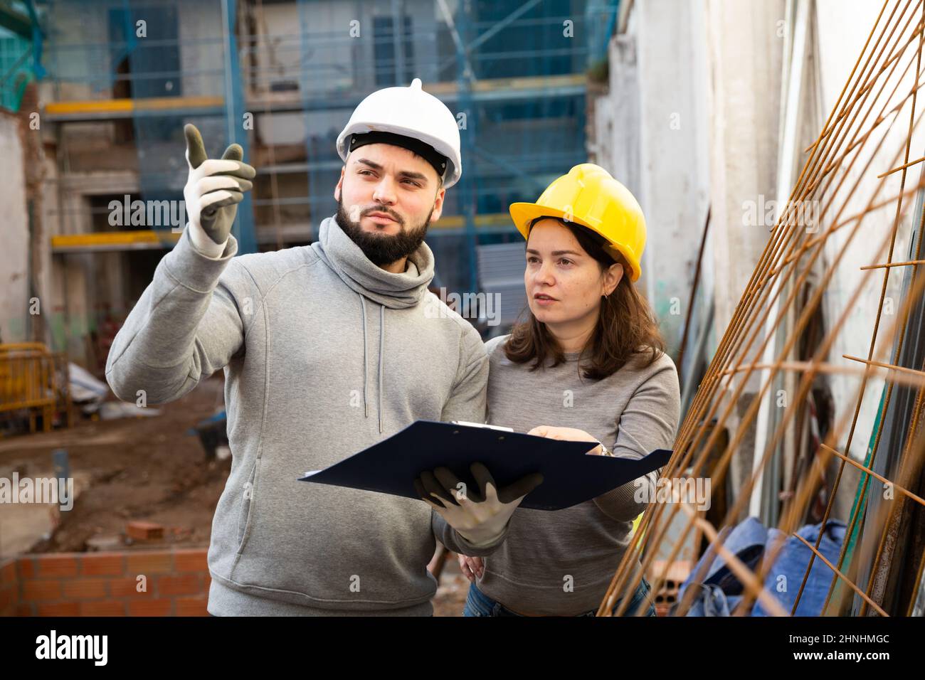 Engineers discussing blueprint at construction site Stock Photo - Alamy
