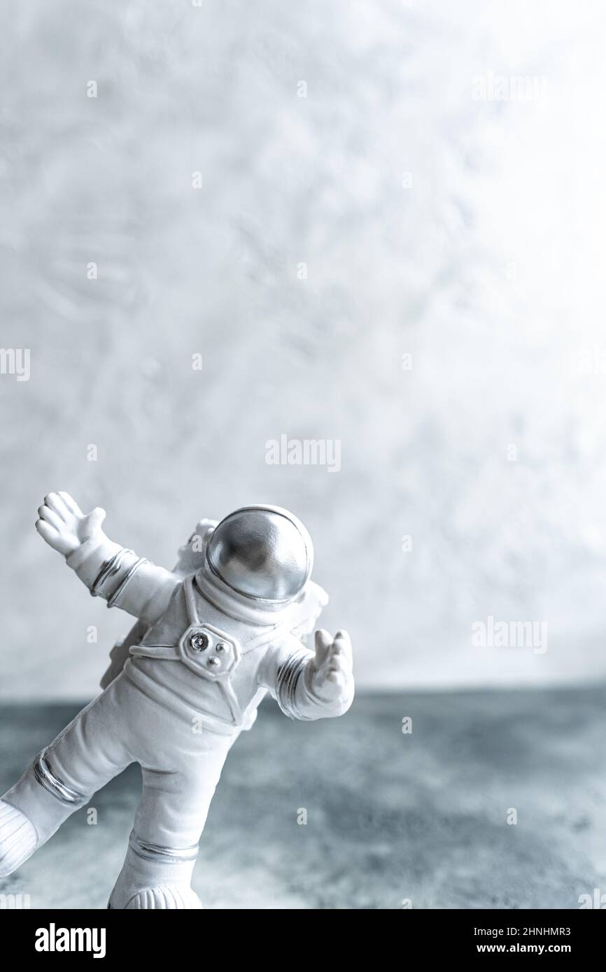 Trendy Miniature astronaut in spacesuit, peeking around corner waving ...
