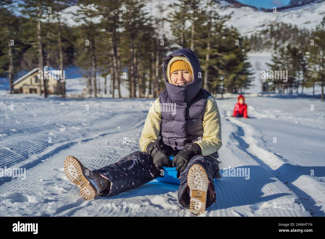 Happy mature woman sledding downhill hi-res stock photography and ...