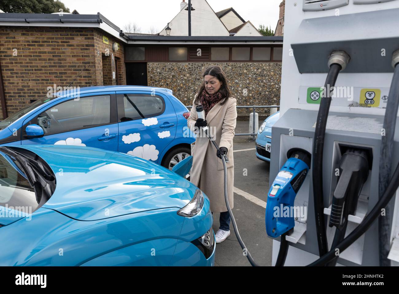 Middle aged lady using 'GeniePoint EV Charging' vehicle charging point ...