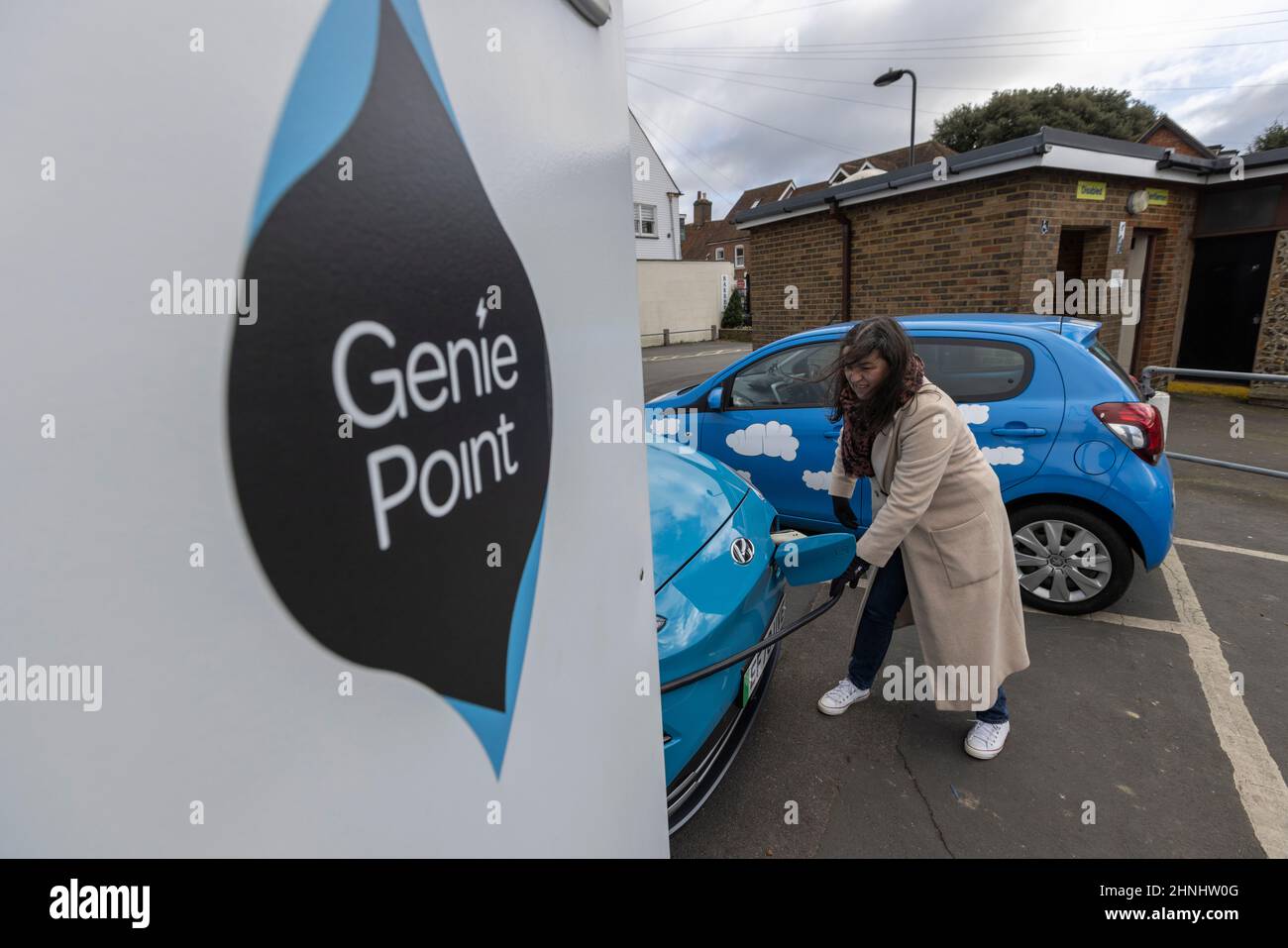 Middle aged lady using 'GeniePoint EV Charging' vehicle charging point ...