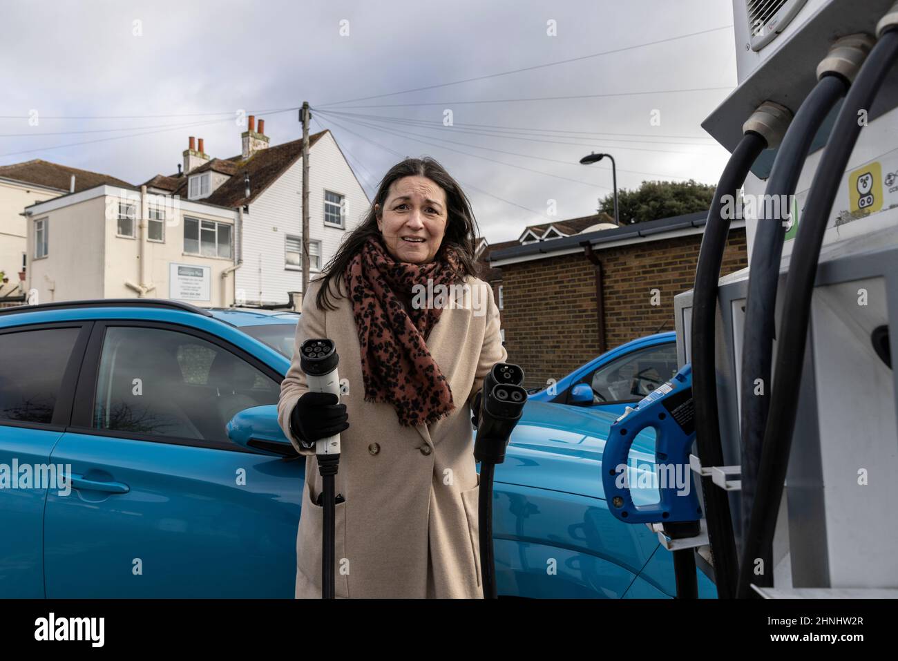 Middle aged lady using 'GeniePoint EV Charging' vehicle charging point ...