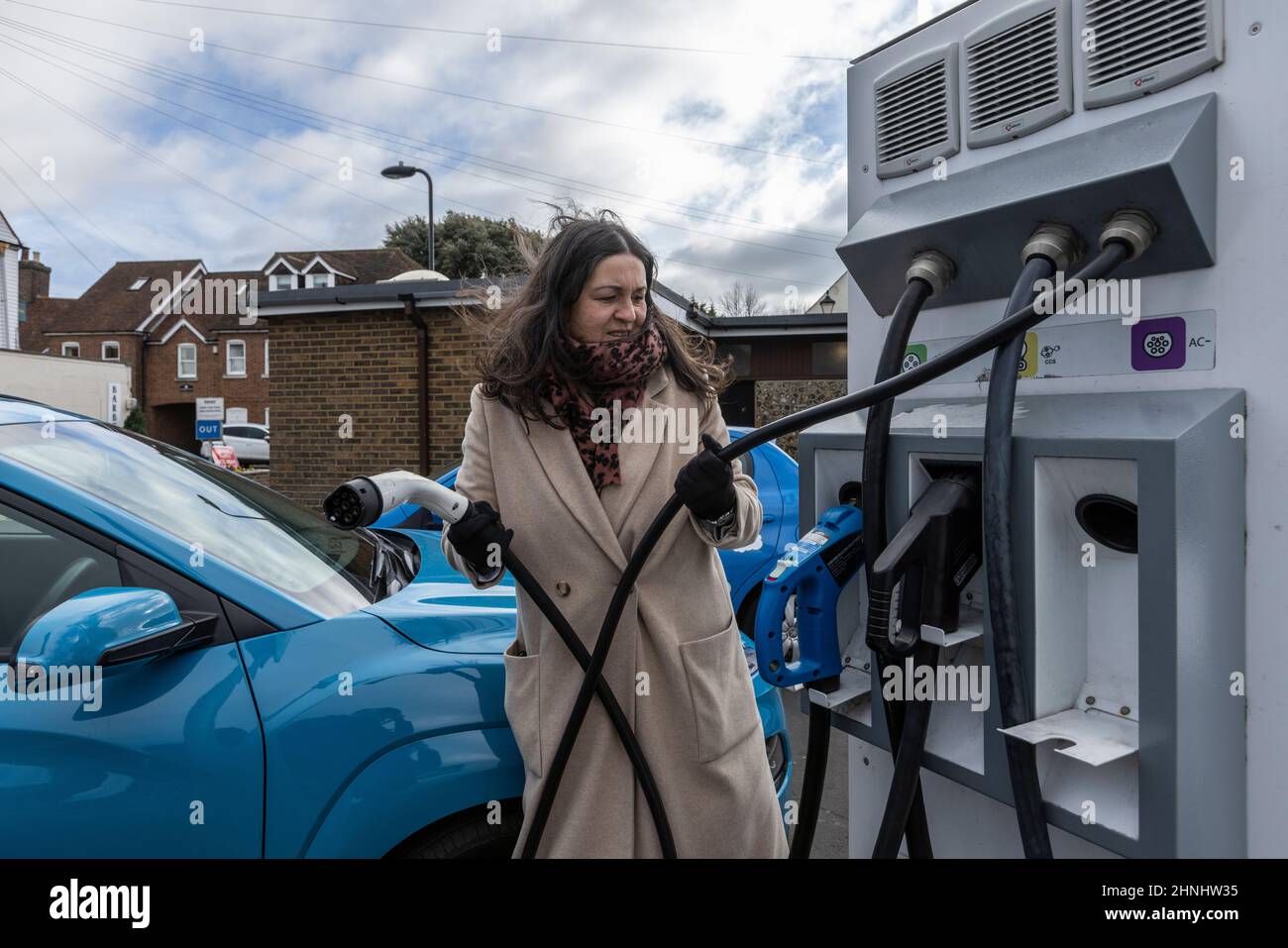 Middle aged lady using 'GeniePoint EV Charging' vehicle charging point ...