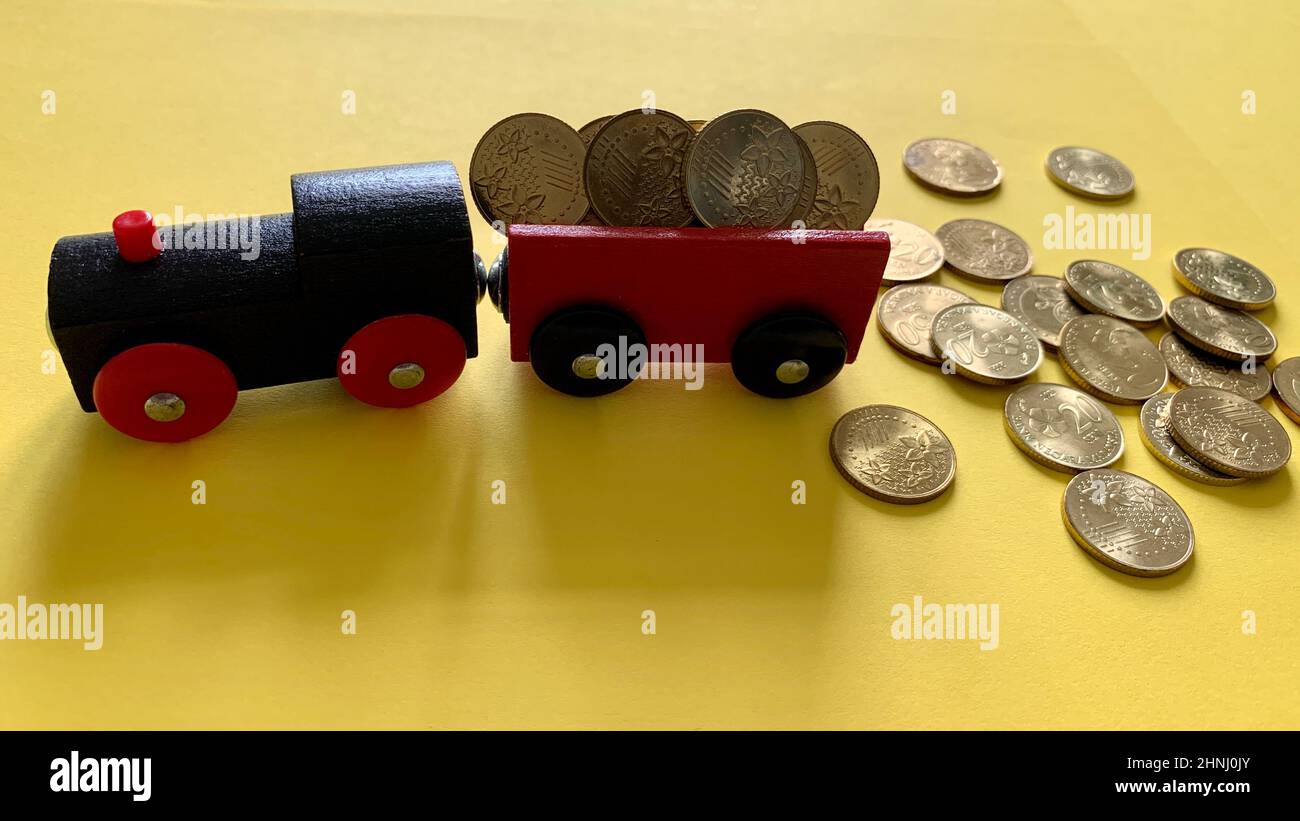Toy train carry gold coins. Investment and business concept Stock Photo ...