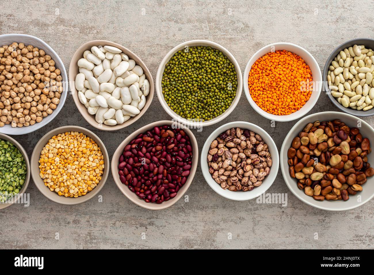 Different types of legumes in bowls, yellow and green peas, mung beans ...