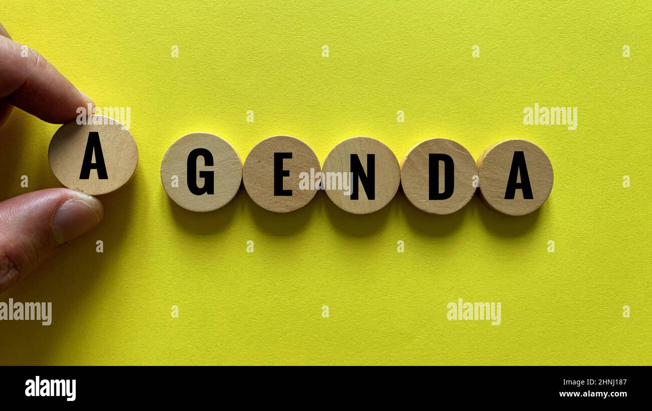 Agenda work on wooden block with yellow background. Business concept ...