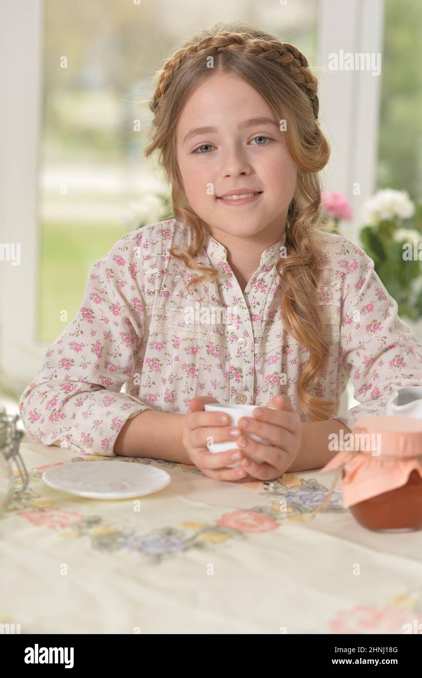 Smiling little girl holding big cup of tea Stock Photo - Alamy