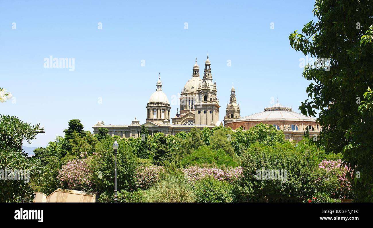 Flowerbed on the Montjuic mountain with the upper part of the domes of ...