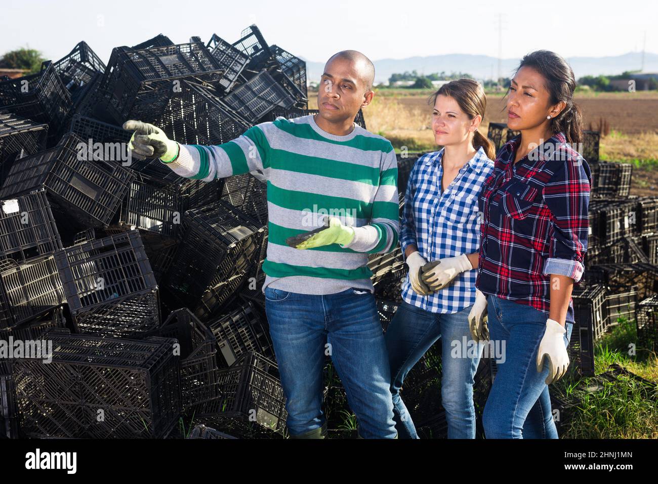 Three positive farmers break in between work on field Stock Photo - Alamy