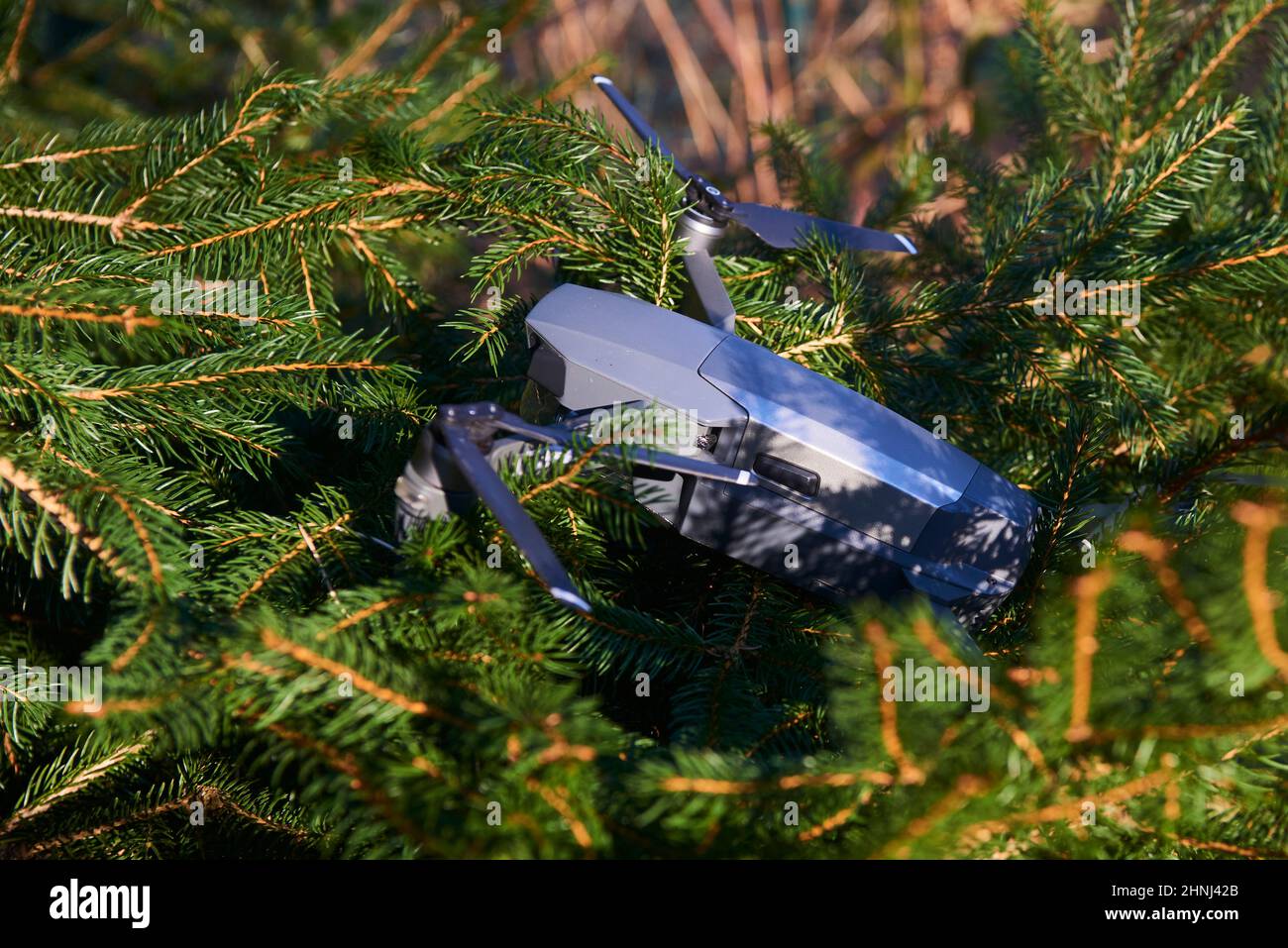 Broken destroyed drone after an accident hanging in the branches of a ...