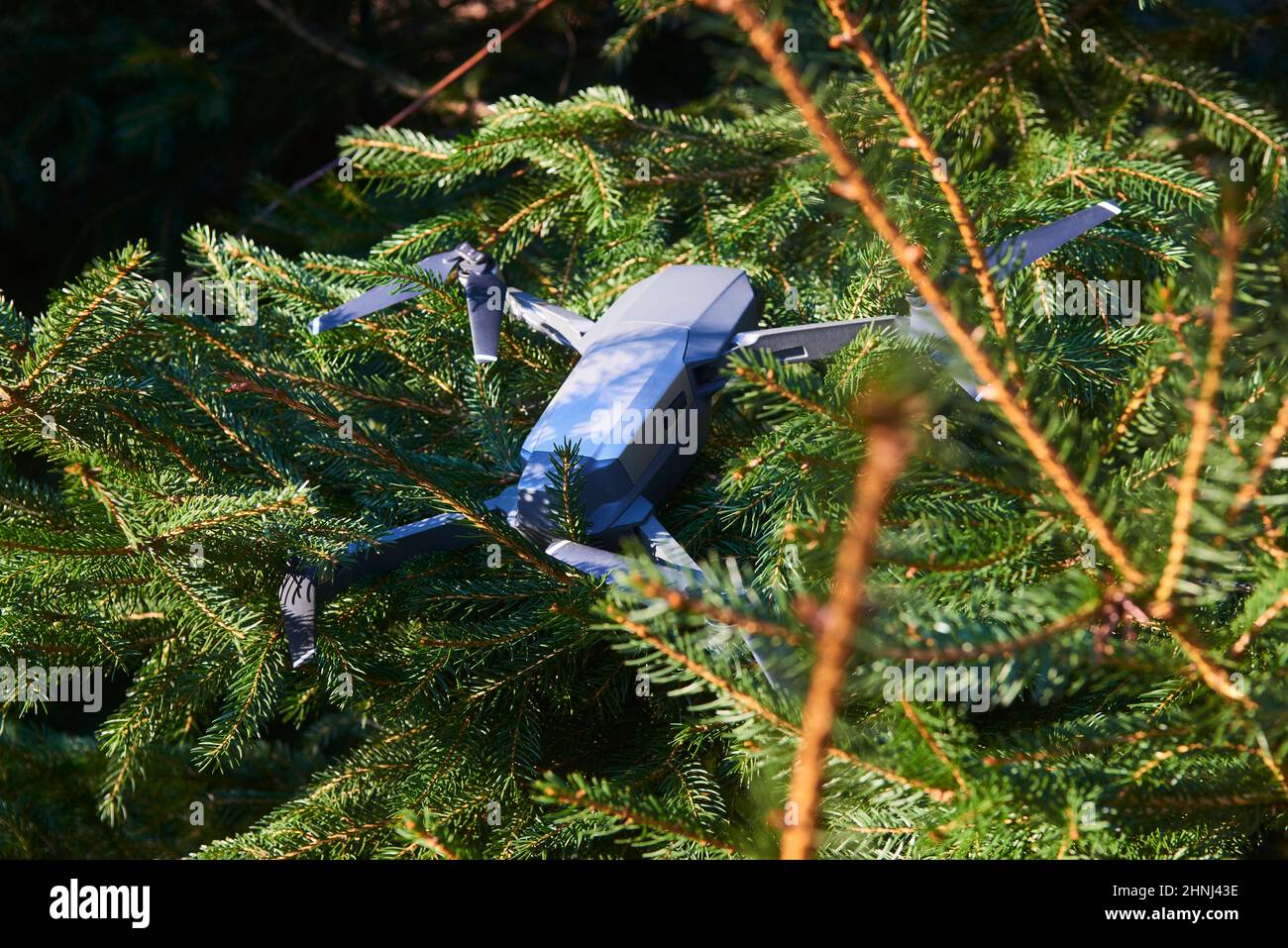 Broken destroyed drone after an accident hanging in the branches of a ...