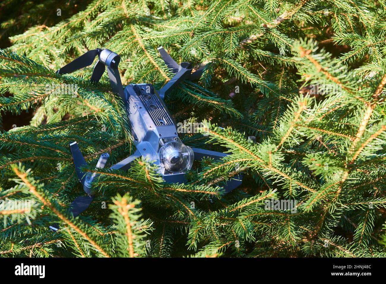 Broken destroyed drone after an accident hanging in the branches of a ...