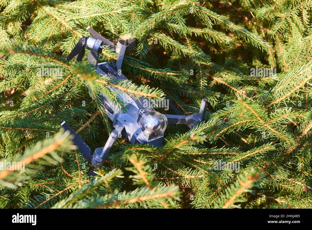 Broken destroyed drone after an accident hanging in the branches of a ...