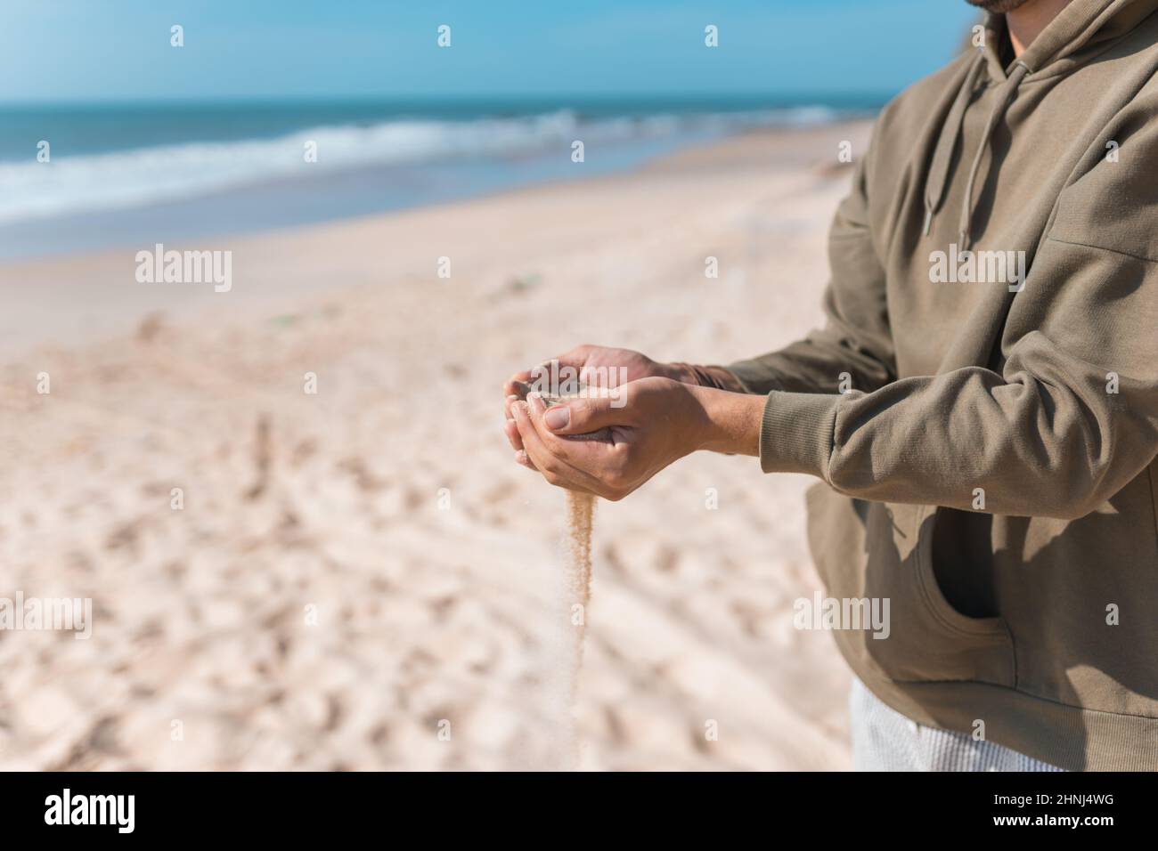 Man holding white sand in his hands. Male palms with the sand on the ...