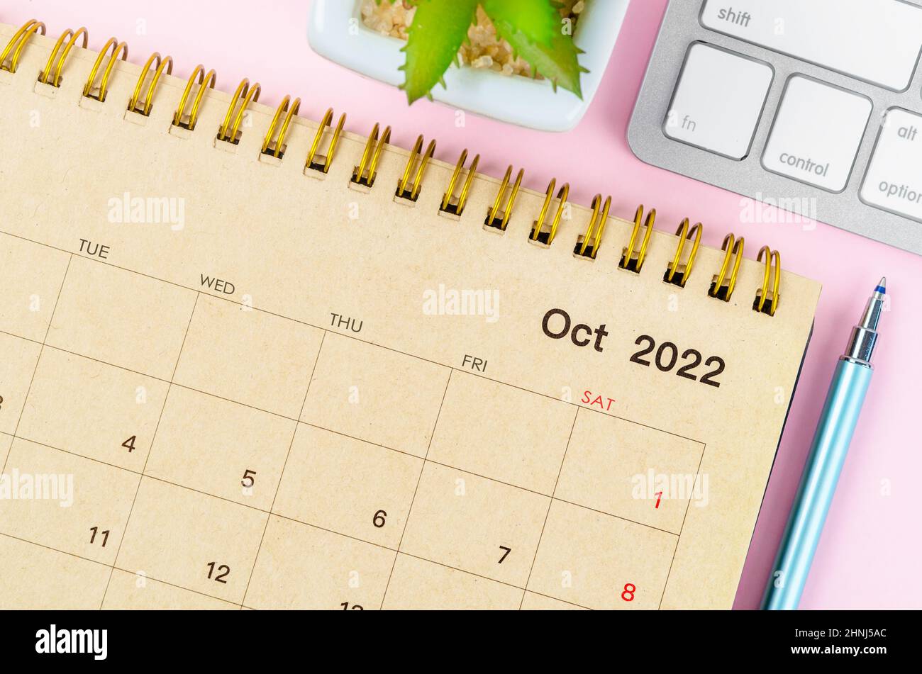 October 2022 desk calendar with keyboard computer on pink background ...