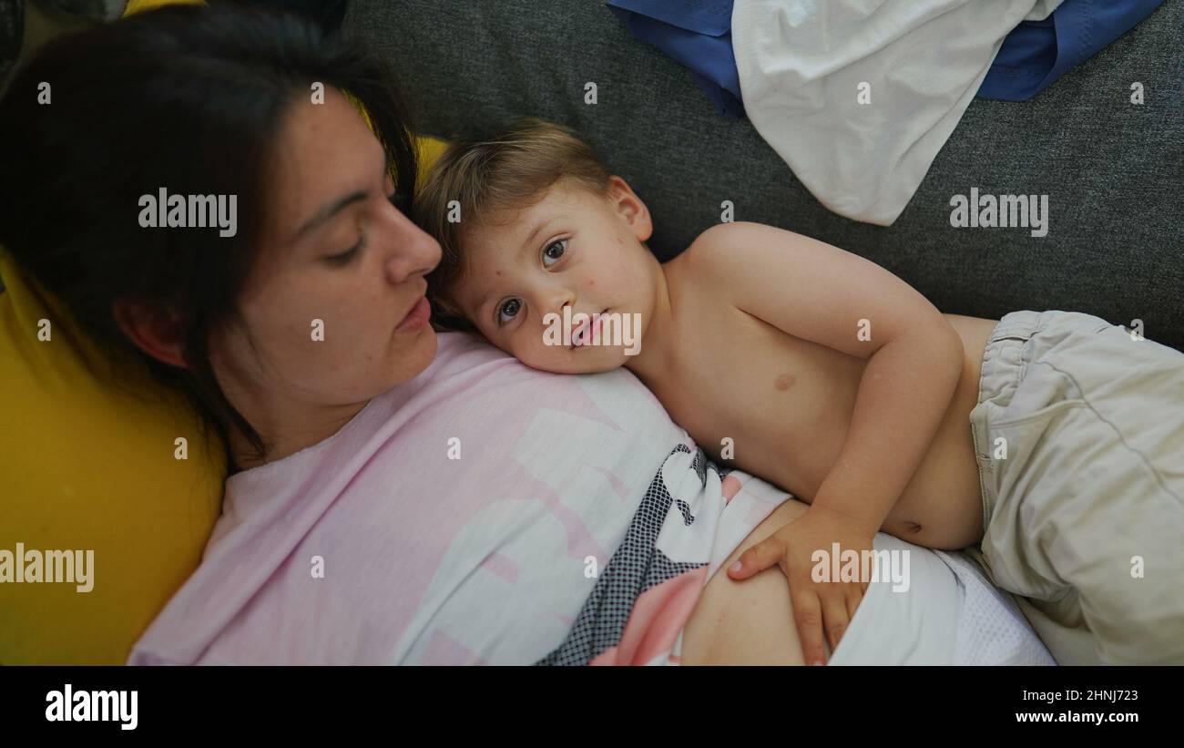 Mother and child lying on sofa resting little boy lies on couch with ...