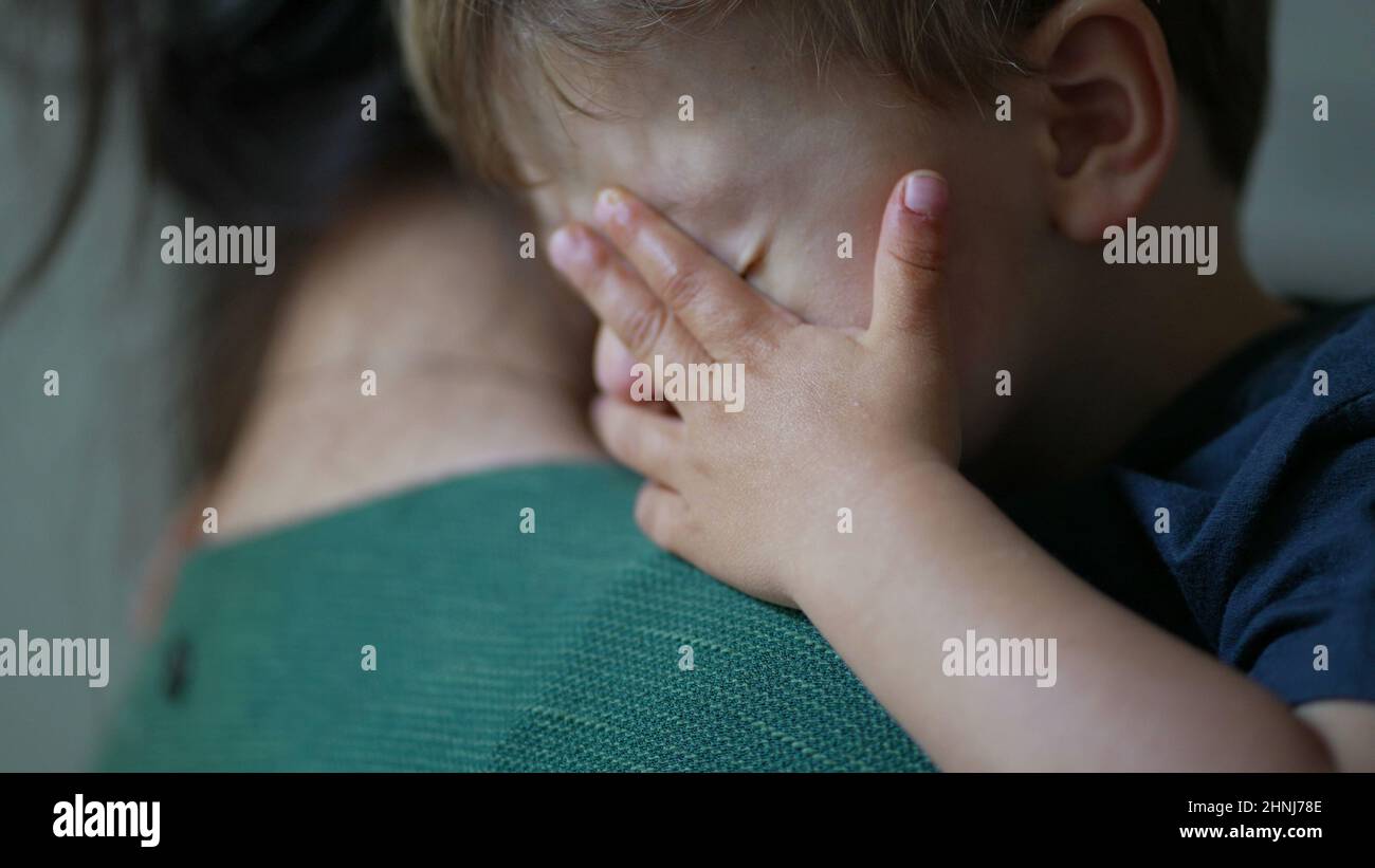 Mother holding crying little boy child wiping tears Stock Photo - Alamy