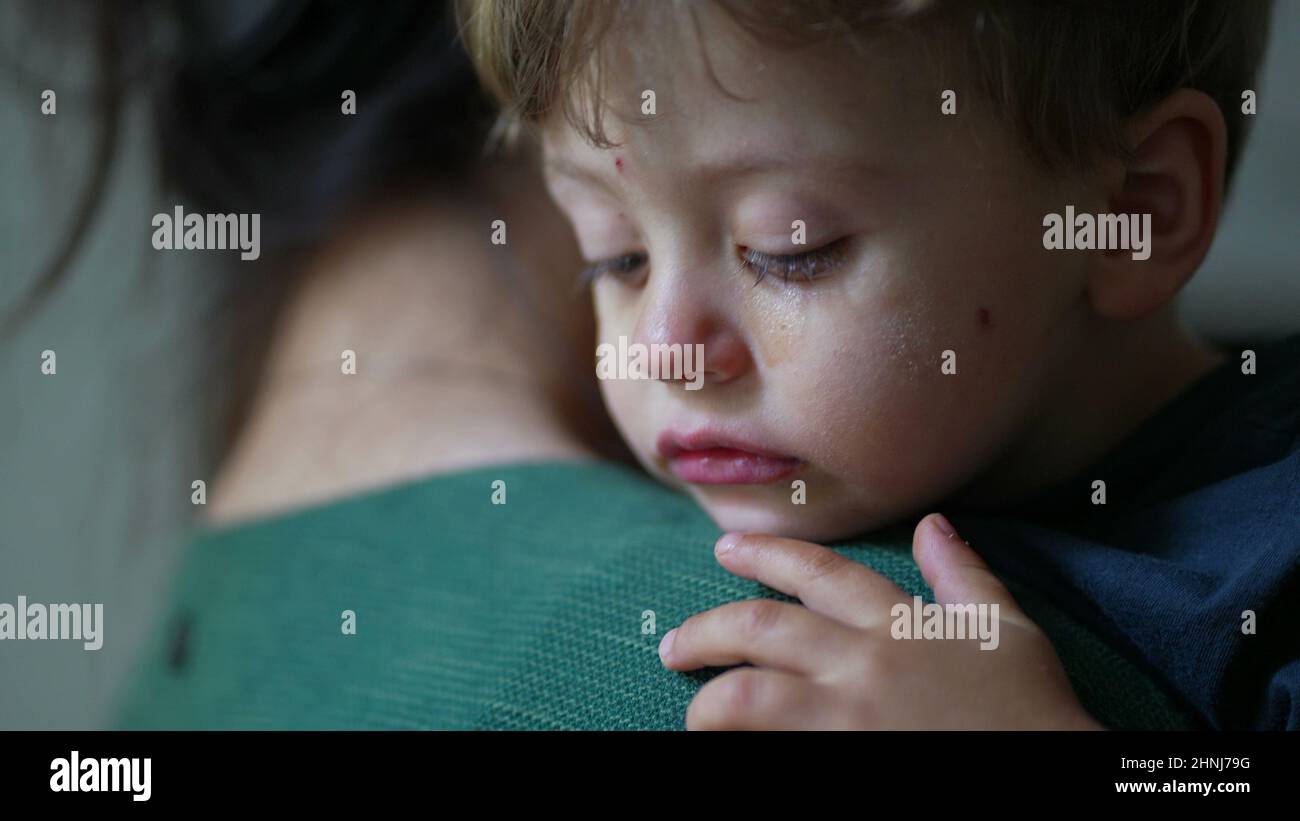 Mother holding crying little boy child wiping tears Stock Photo - Alamy
