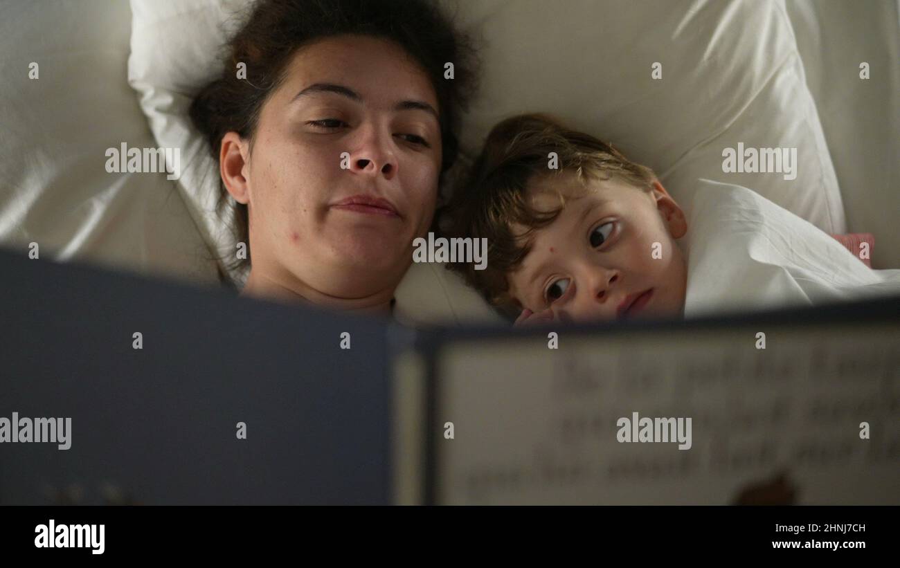 Mother reading a bedtime story to child in bed before sleep Stock Photo ...