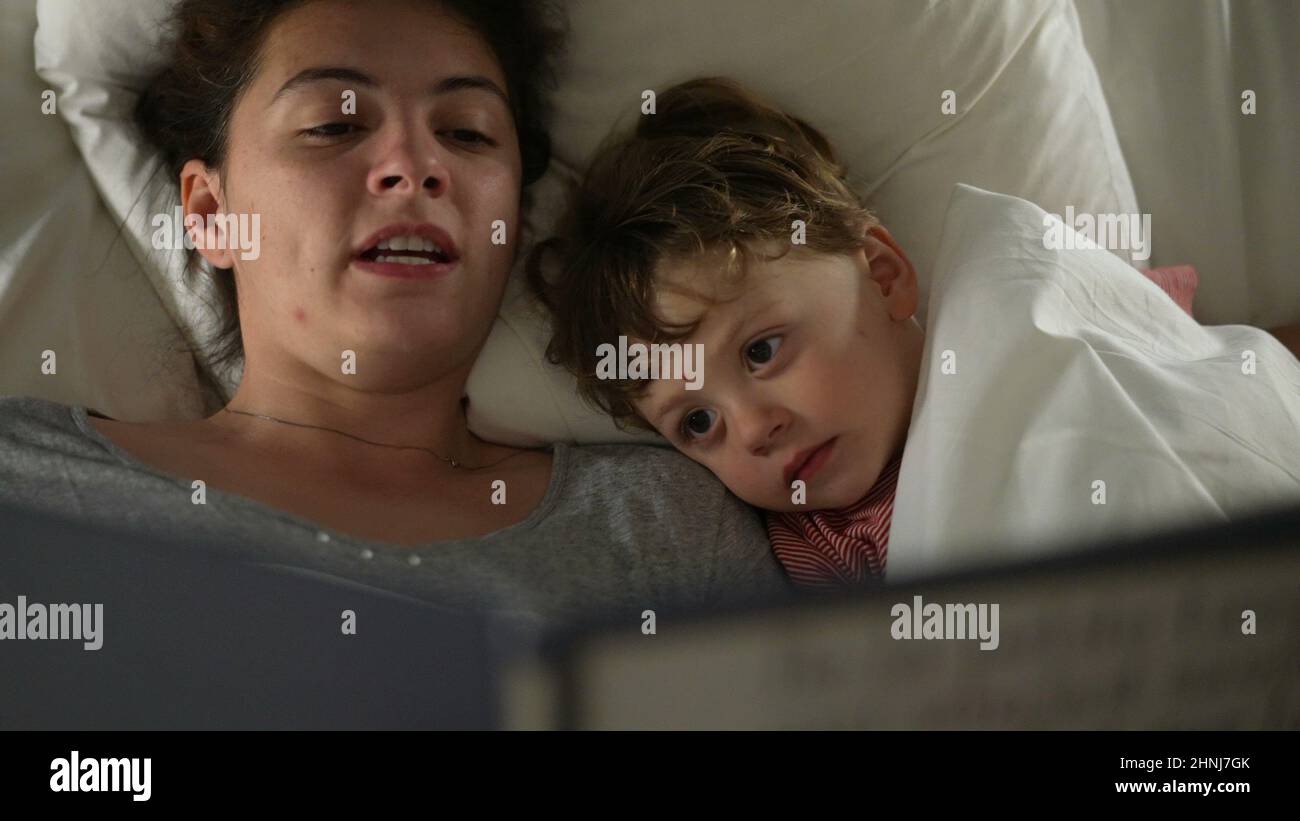 Mother reading a bedtime story to child in bed before sleep Stock Photo ...