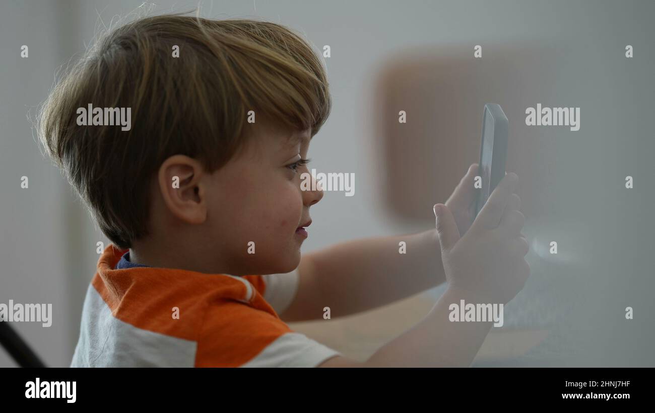 One child holding smartphone looking at screen kid using phone ...