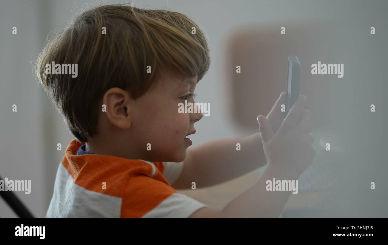 One child holding smartphone looking at screen kid using phone ...