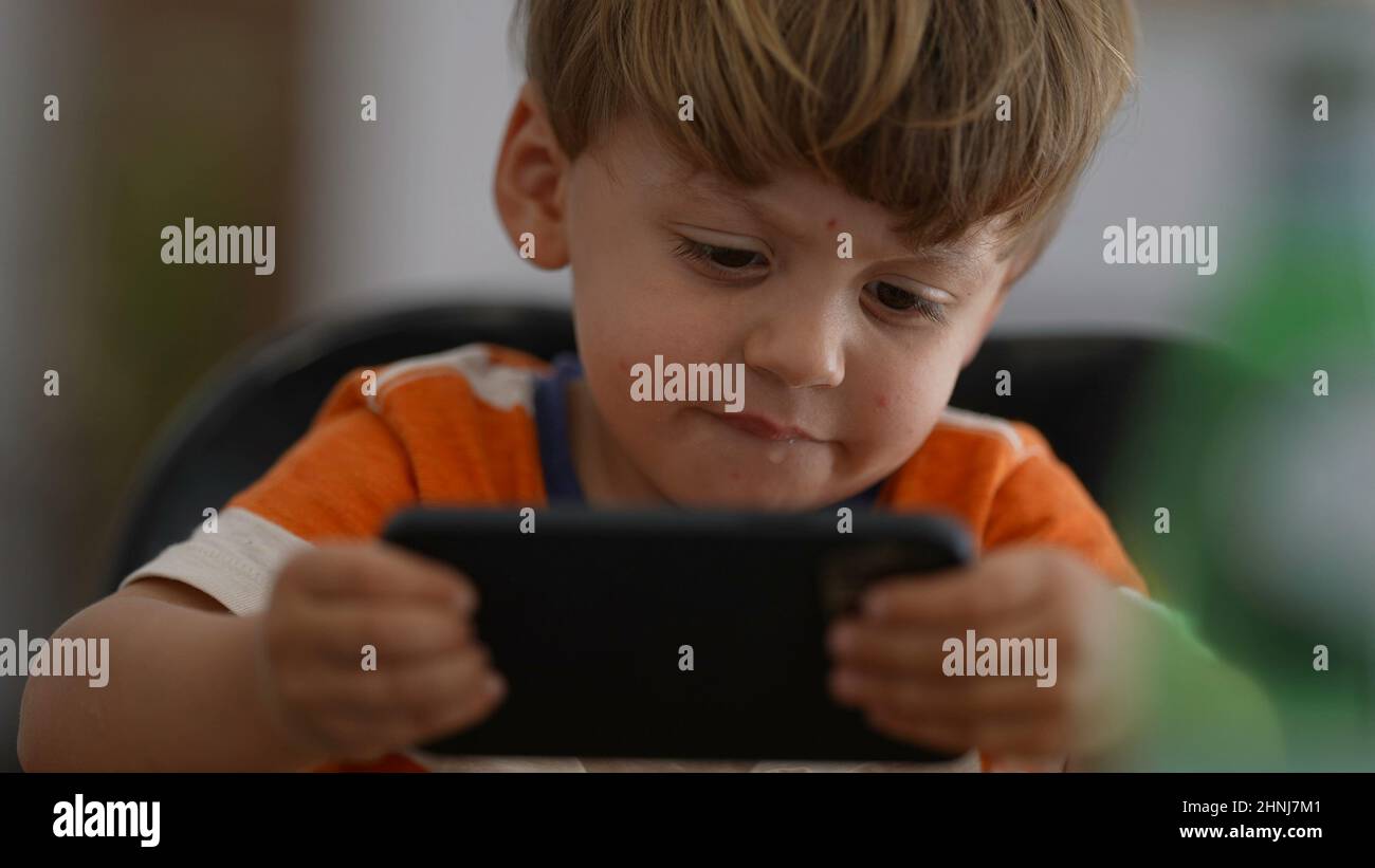 One kid using cellphone device child holding phone Stock Photo - Alamy
