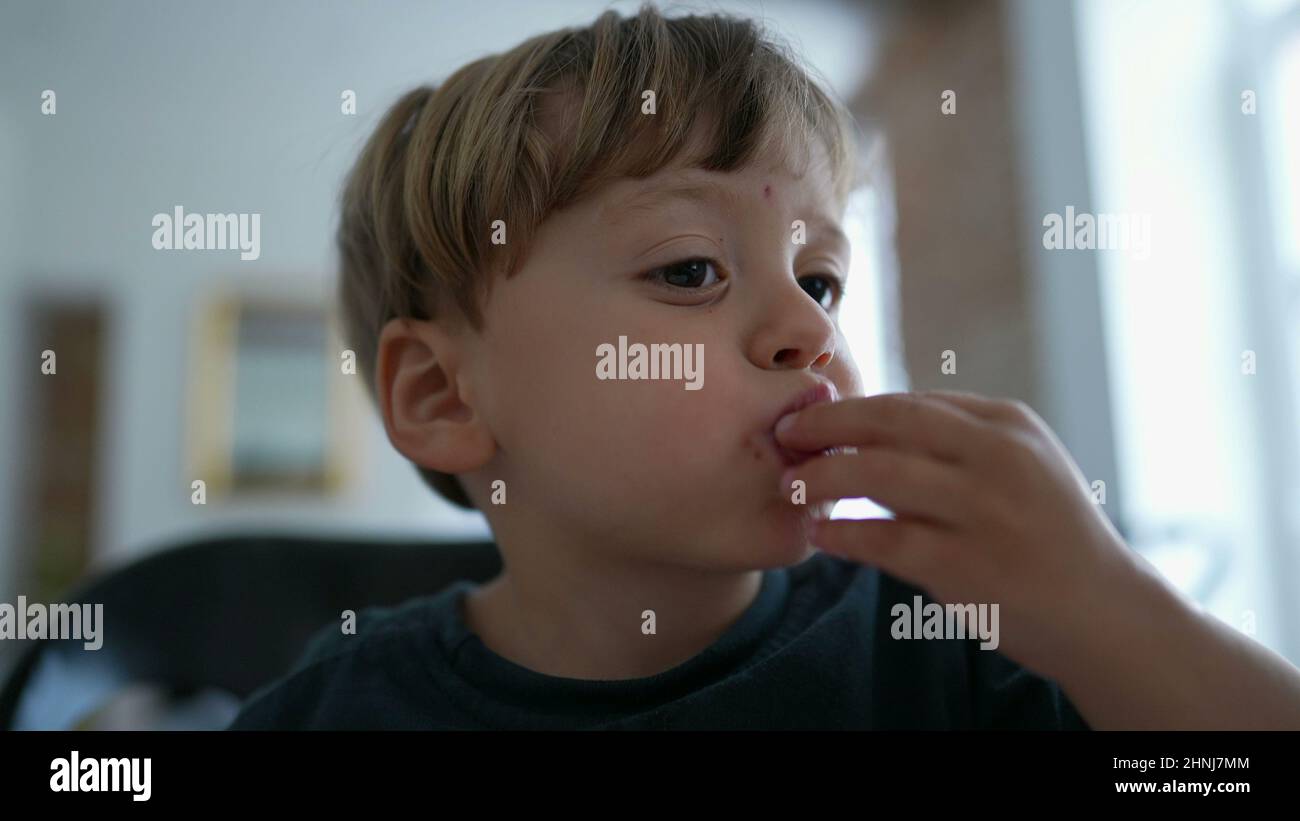 One little boy eating bread at home child eats carb food Stock Photo ...