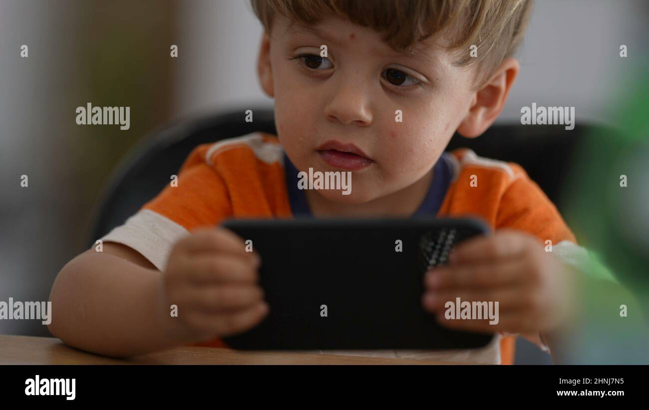 One kid using cellphone device child holding phone Stock Photo - Alamy