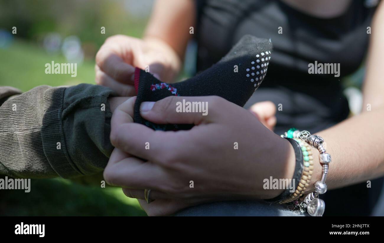 Parent putting socks into child feet Stock Photo - Alamy