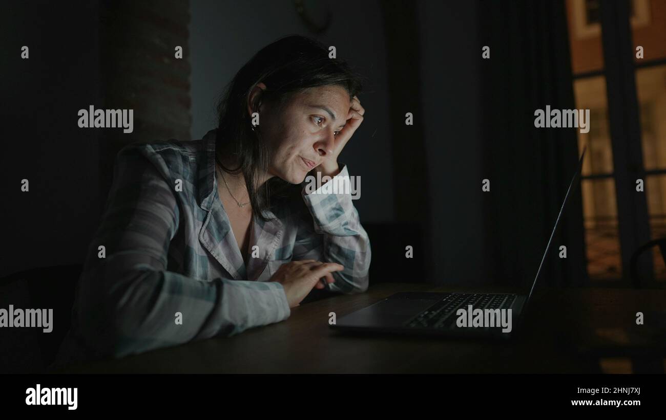 Person reading content online at night in front of laptop screen Stock ...