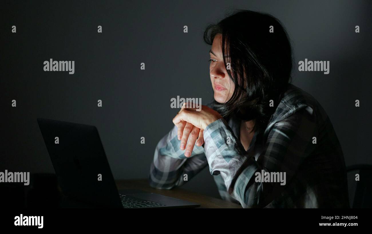 Person reading content online at night in front of laptop screen Stock ...