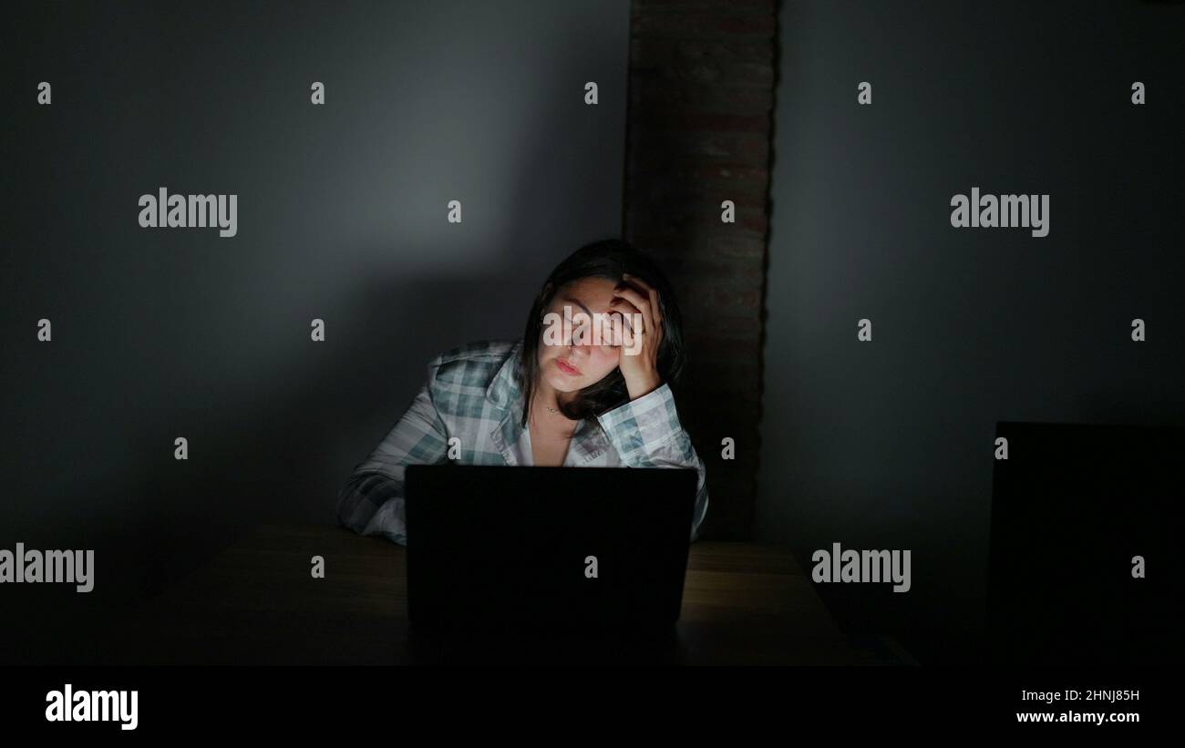 Tired woman in front of computer screen at night alone Stock Photo - Alamy