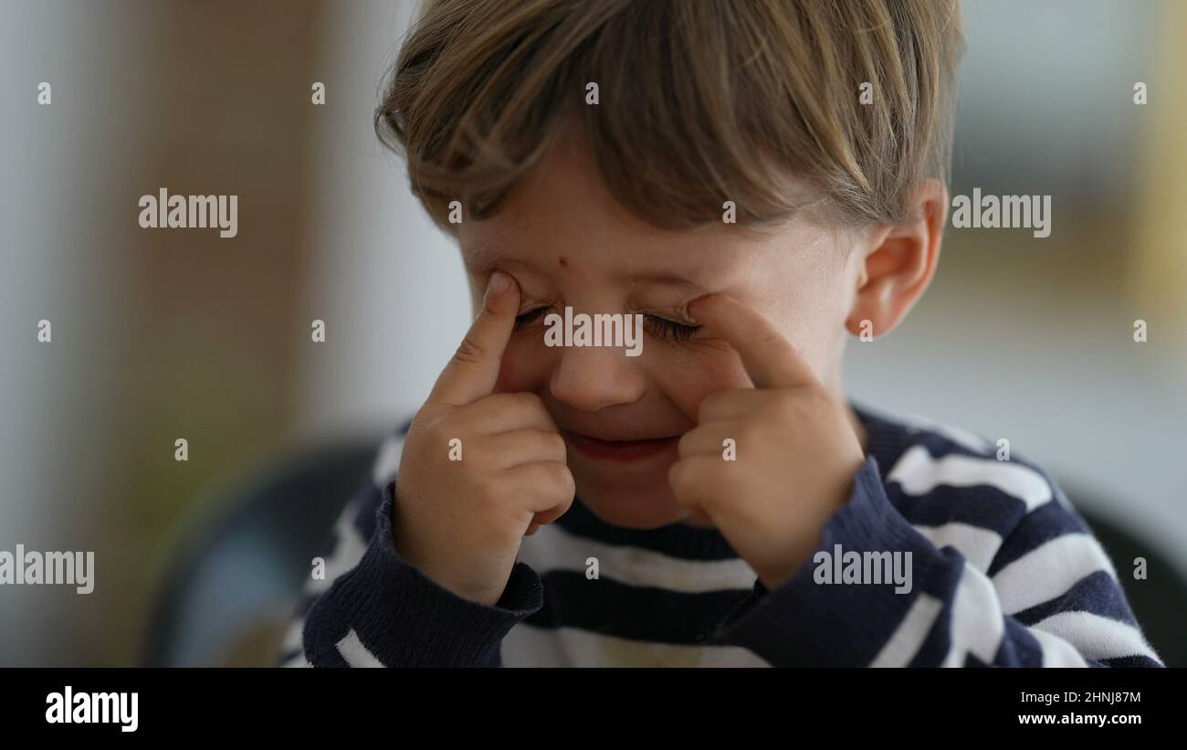 Toddler touching eyes and face with hand child rubbing face with finger ...