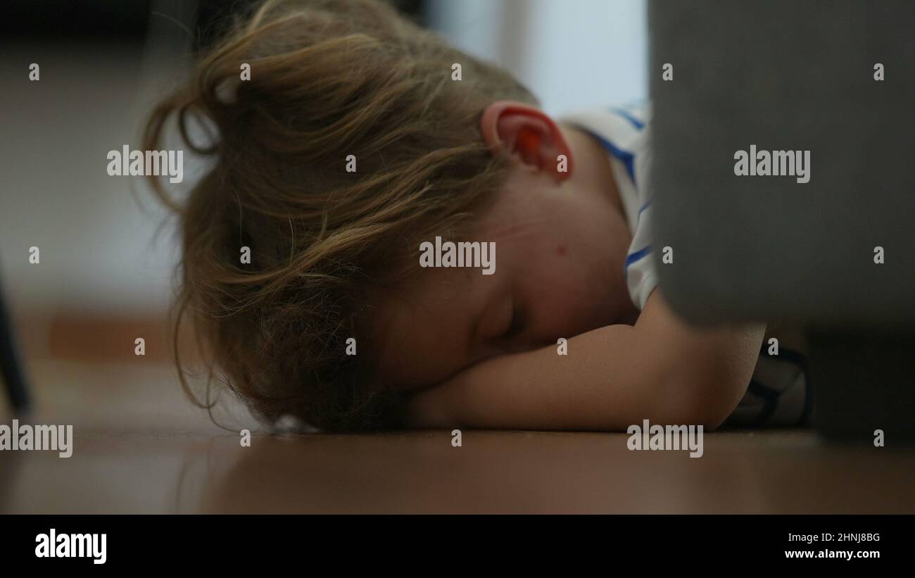 Upset little boy lying on floor at home angry sad child Stock Photo - Alamy