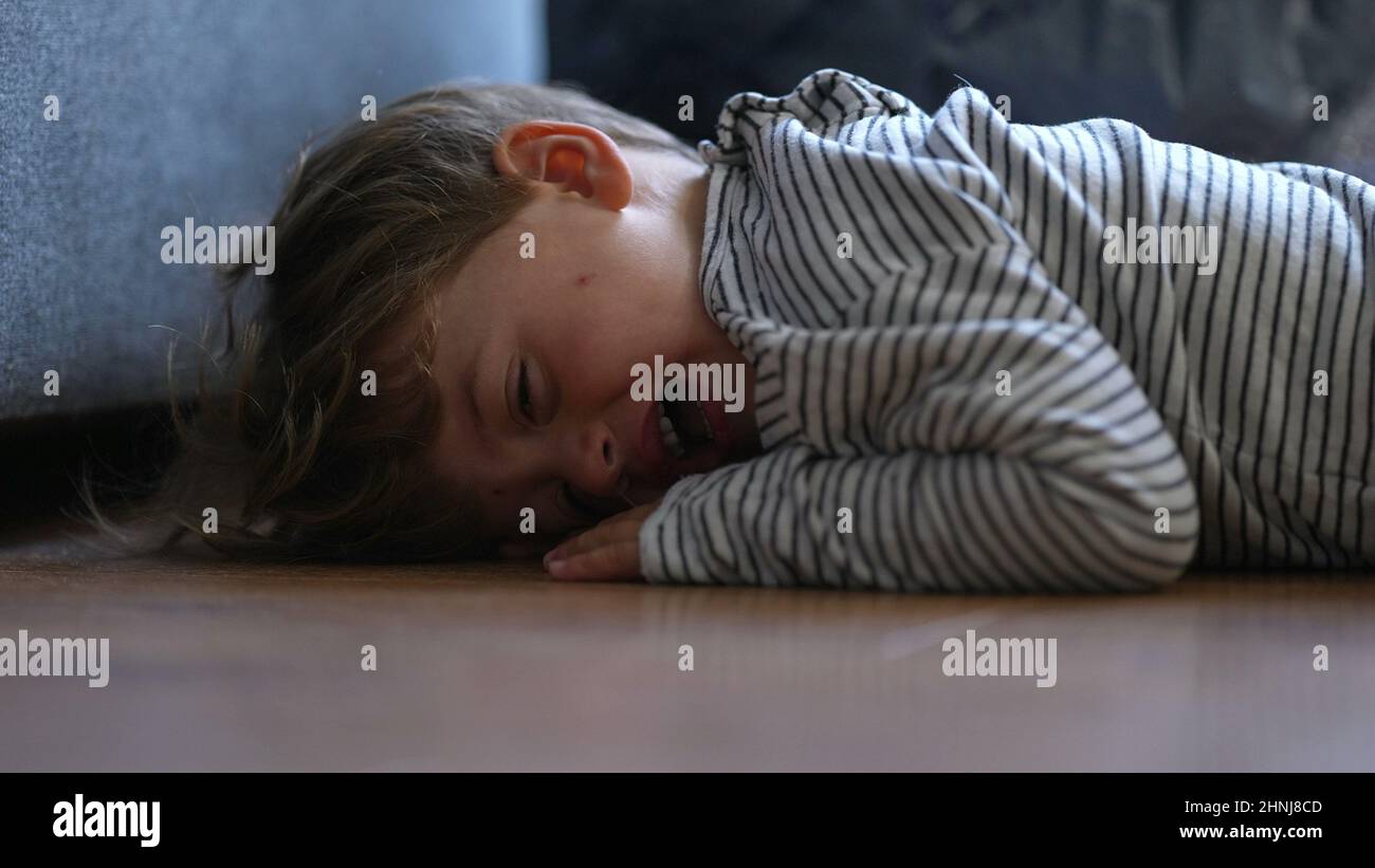 Upset Small boy crying on floor Stock Photo - Alamy