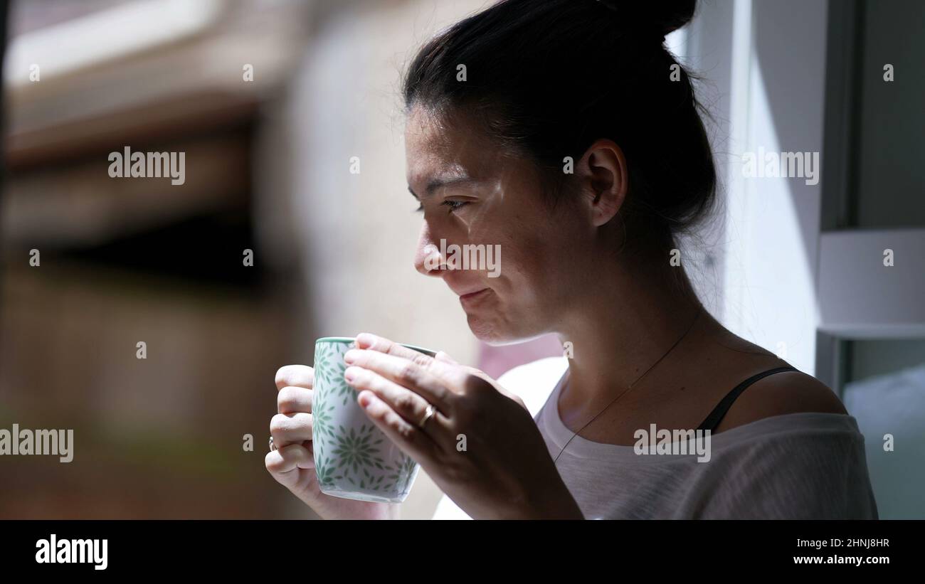 Woman sipping tea person drinking coffee looking outside Stock Photo ...