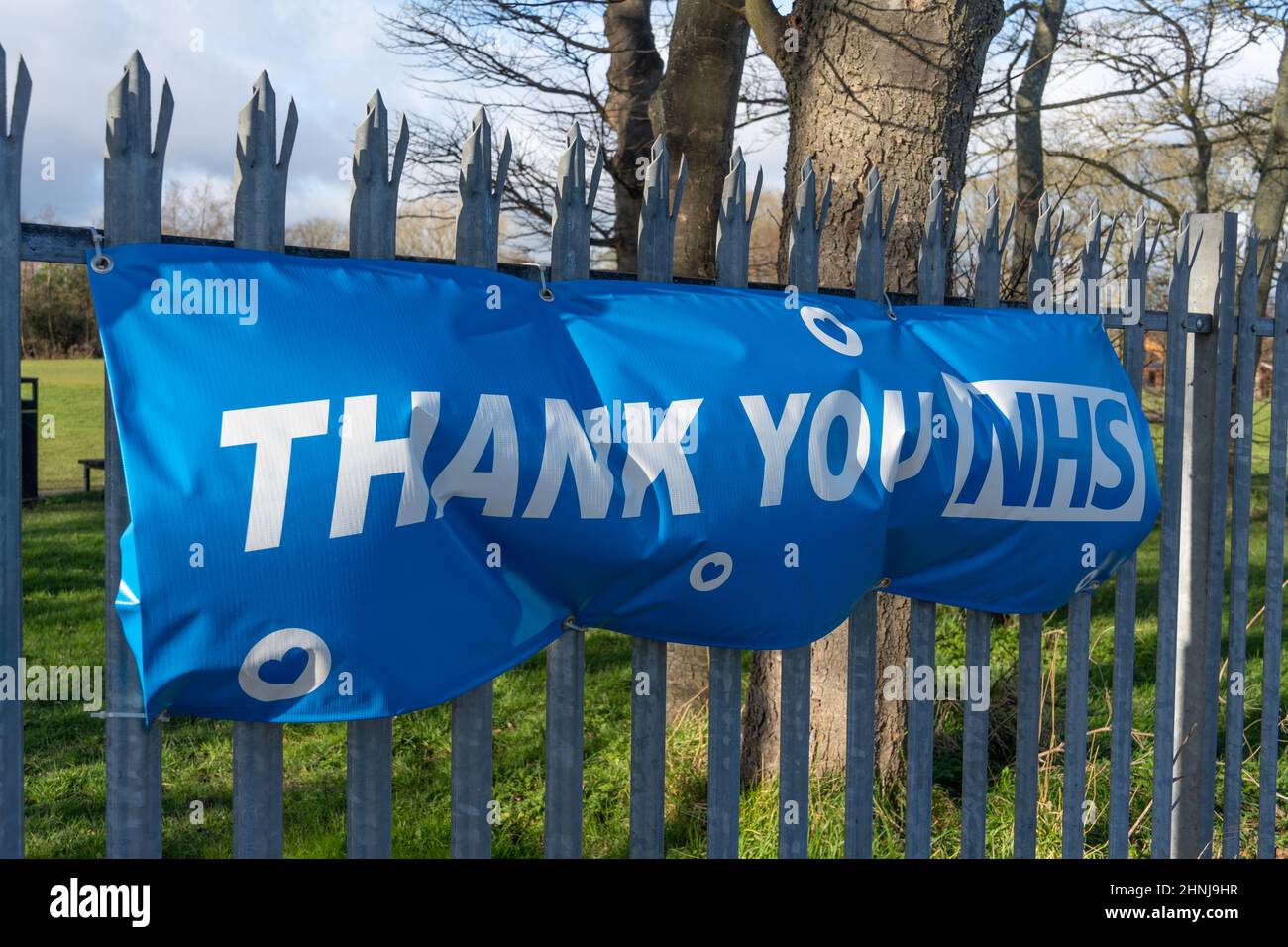 A banner reads, 'Thank you NHS' on park railings opposite the entrance ...